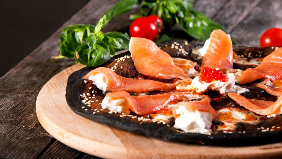 Pizza negra con salmón ahumado y queso crema