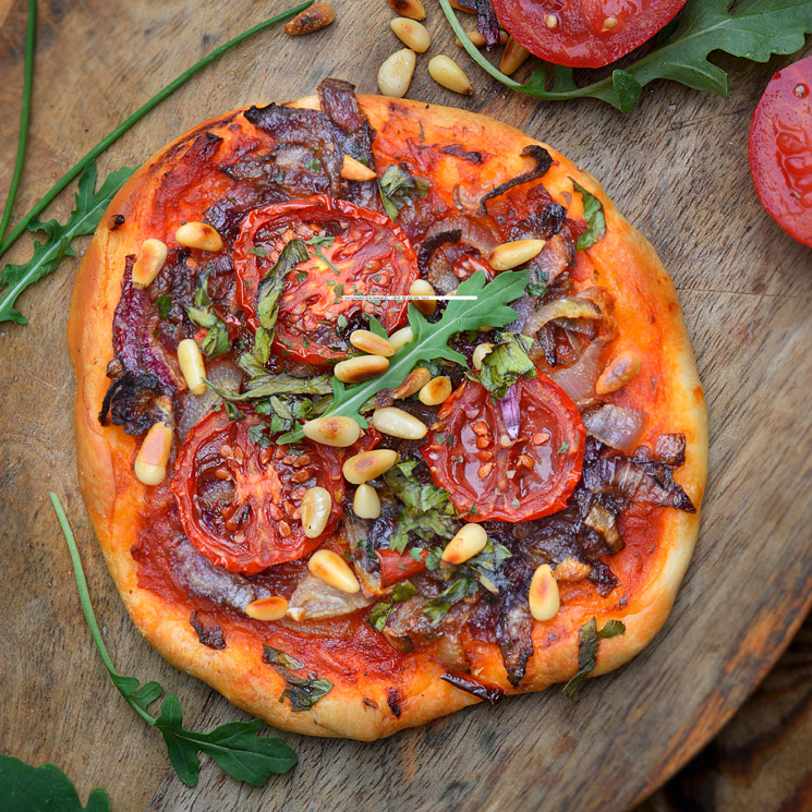 Pizza de tomate, cebolla y piñones