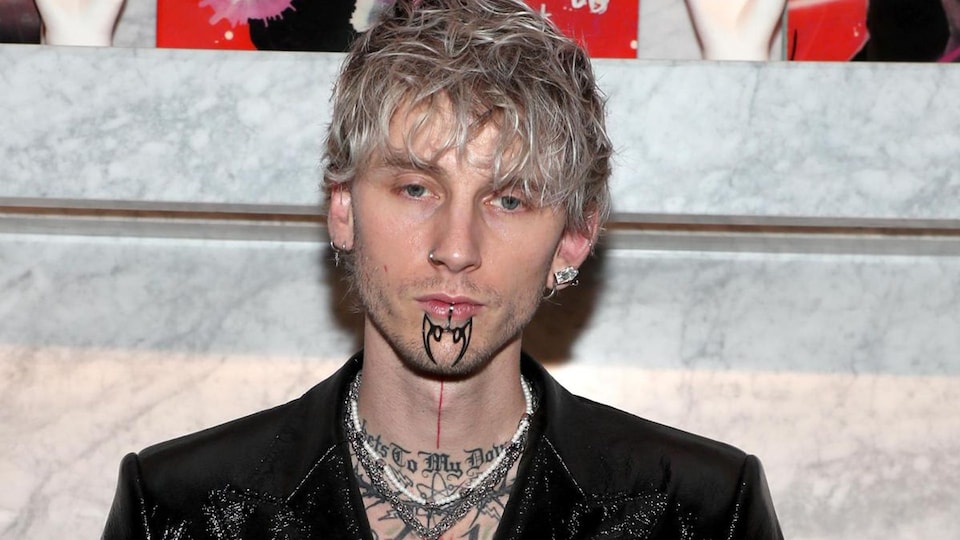 Machine Gun Kelly covers his upper body with blackout tattoo