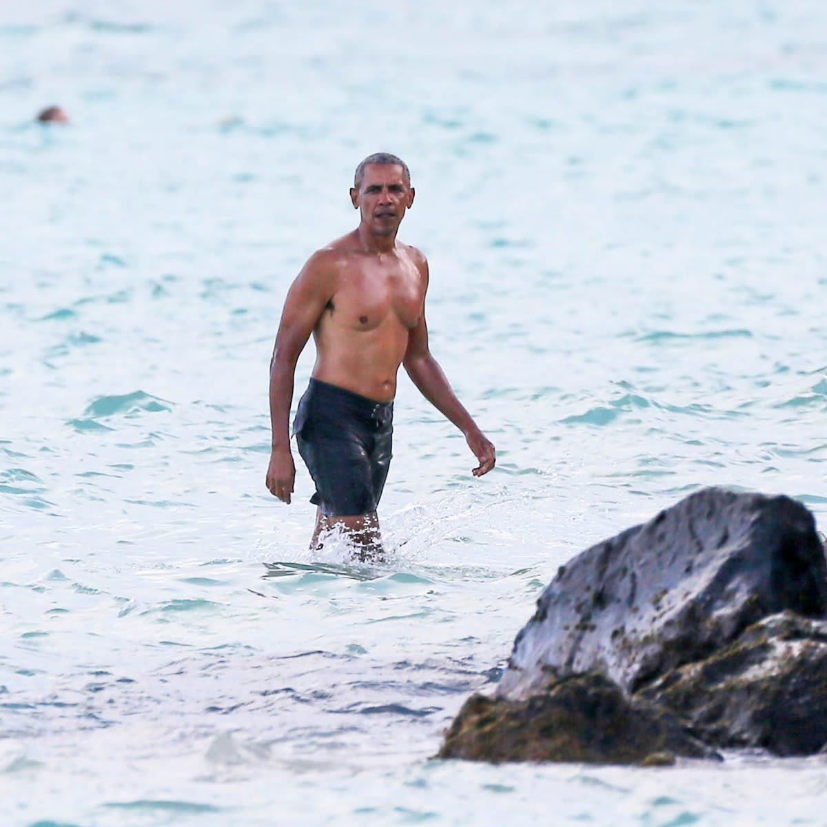 Barack Obama paddle-boards shirtless in his home state Hawaii