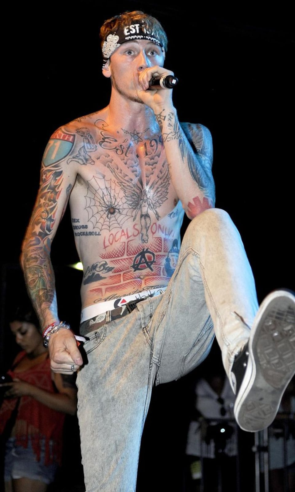 Machine Gun Kelly covers his upper body with blackout tattoo