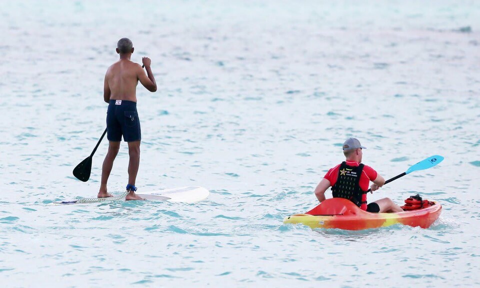 Barack Obama paddle-boards shirtless in his home state Hawaii